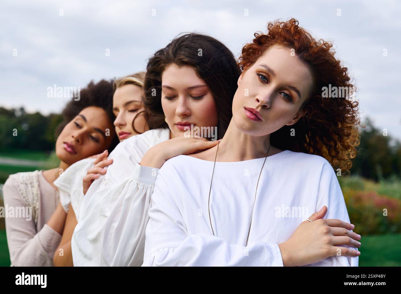 Four fashionable women embrace the joy of spring outdoors in a serene ...