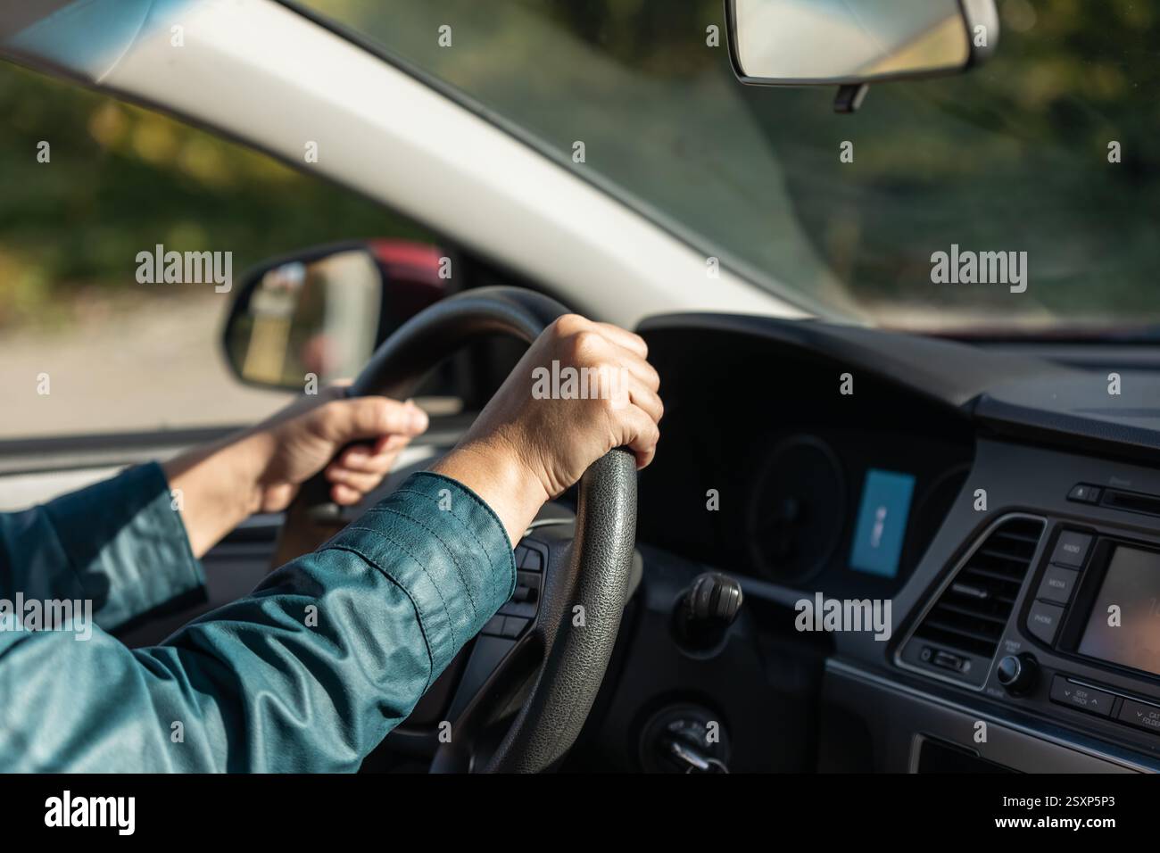 Person driving with both hands on the steering wheel. Female driver ...