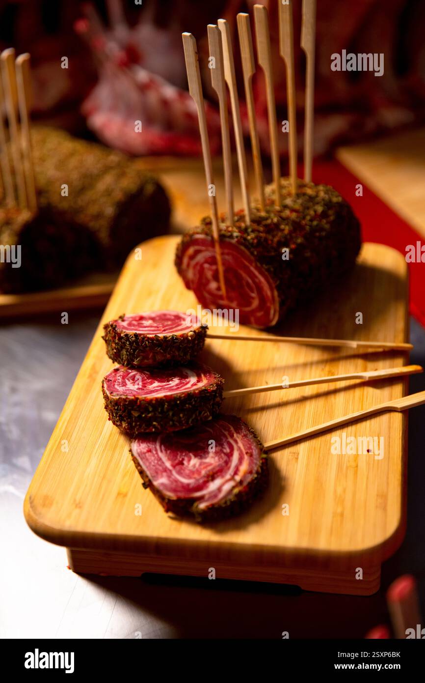 Row beef roulade cuts with skewers on a wooden cutting board in butcher ...