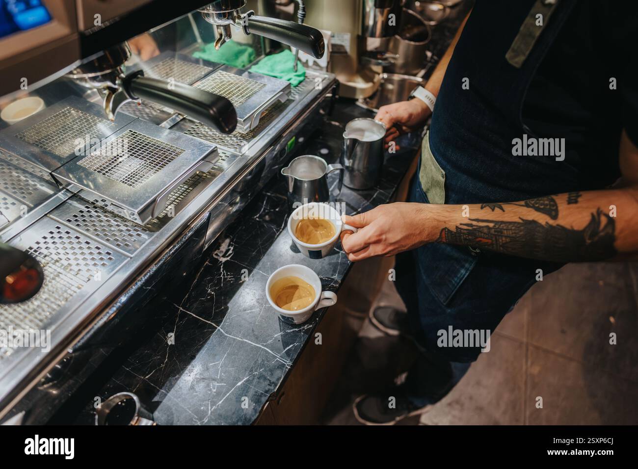 Barista preparing espresso at a coffee counter with a professional ...