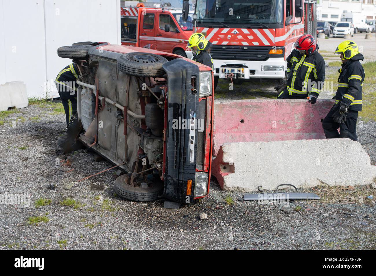 Firefighters securing overturned car after road accident Stock Photo ...