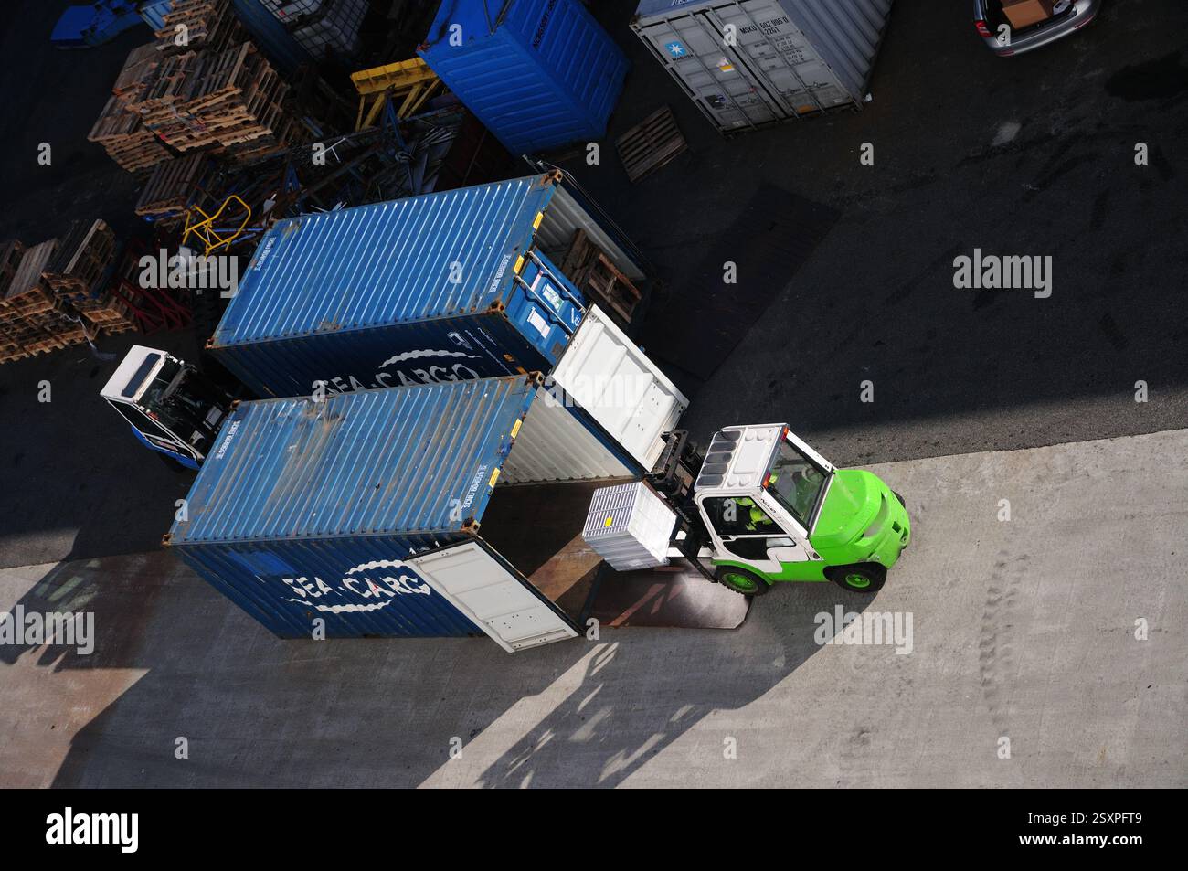 A fork-lift truck loading a shipping container on the quayside at the ...