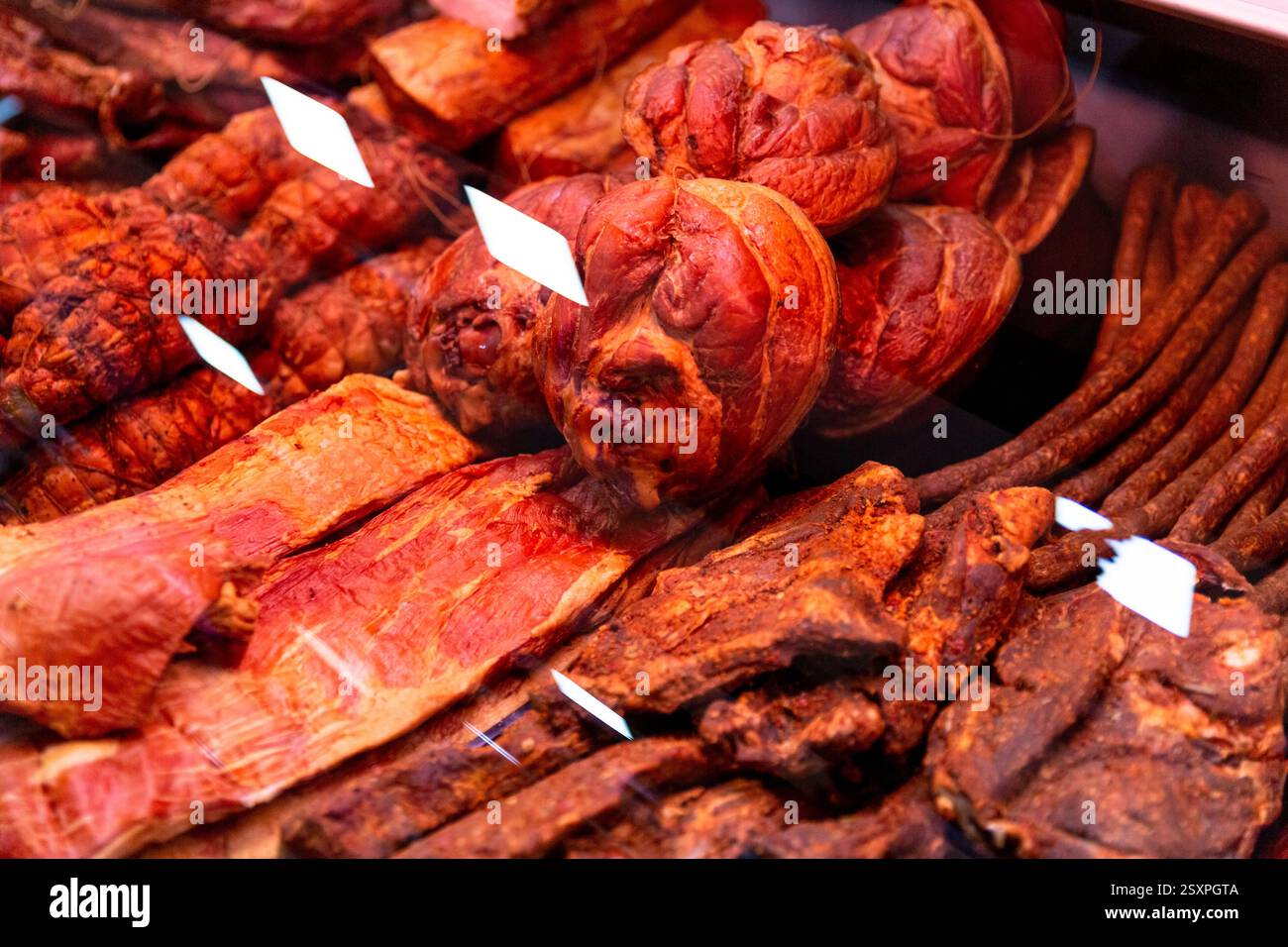 Freshly smoked sausage and ham on the counter of Butchers shop. Meat ...