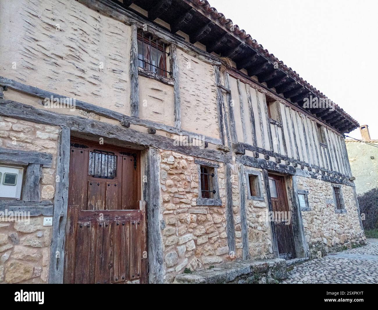 A historic half-timbered house with wooden beams, a stone facade, and ...