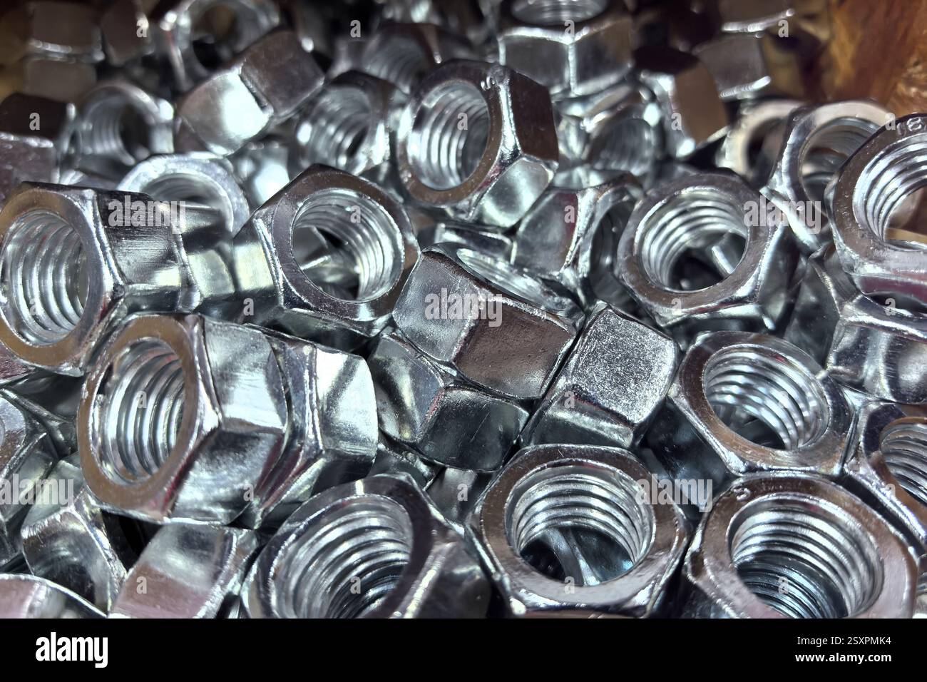 A close-up view reveals a collection of shiny metallic nuts arranged ...