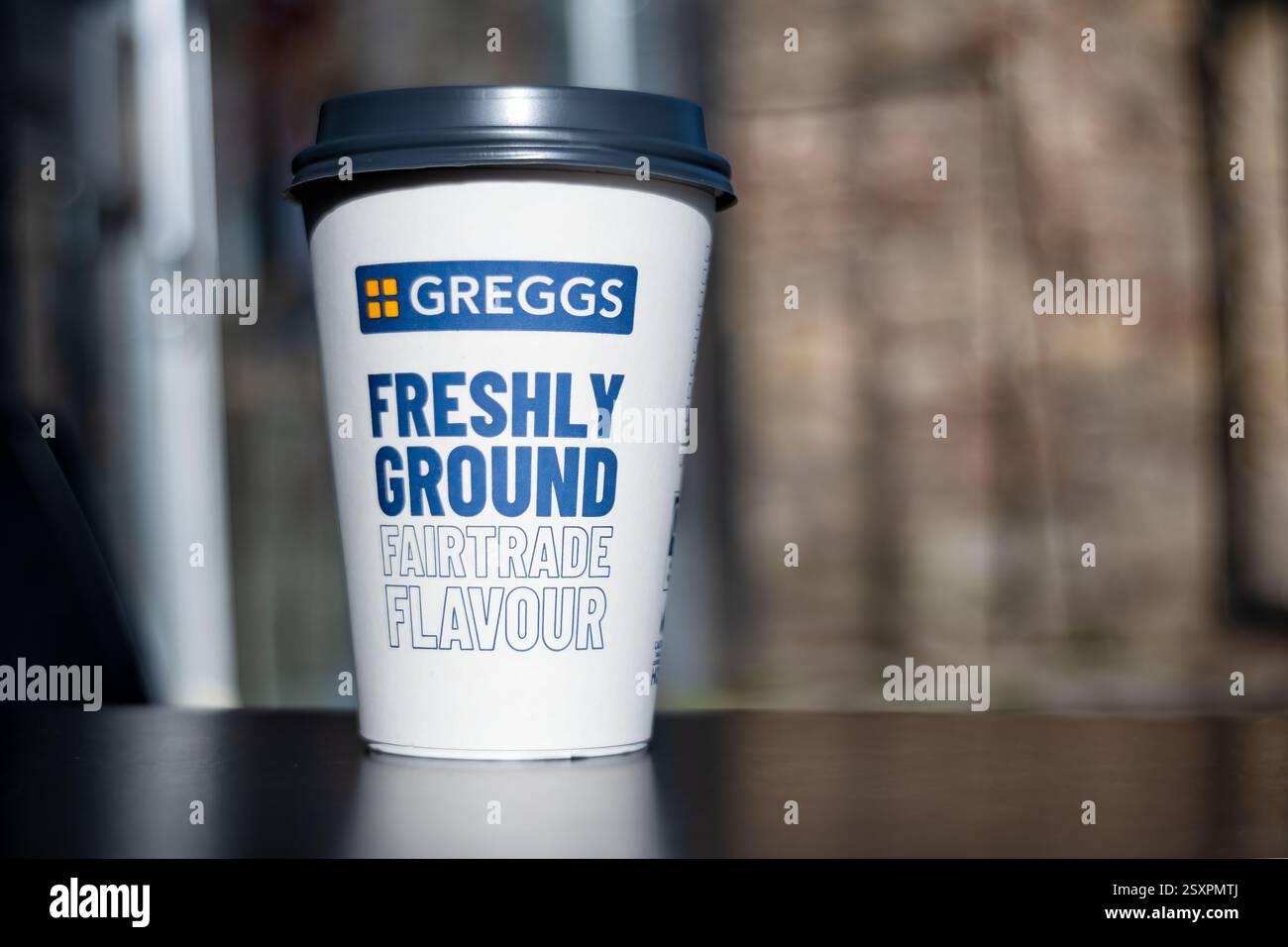 Bristol, UK. A Greggs disposable coffee cup on a table outside one of ...