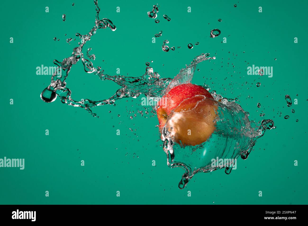 Stop motion water splash and red apple on emerald background Stock ...