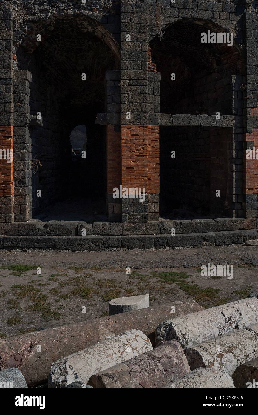Sections of fallen marble columns lie in the walkway or ambulacrum ...