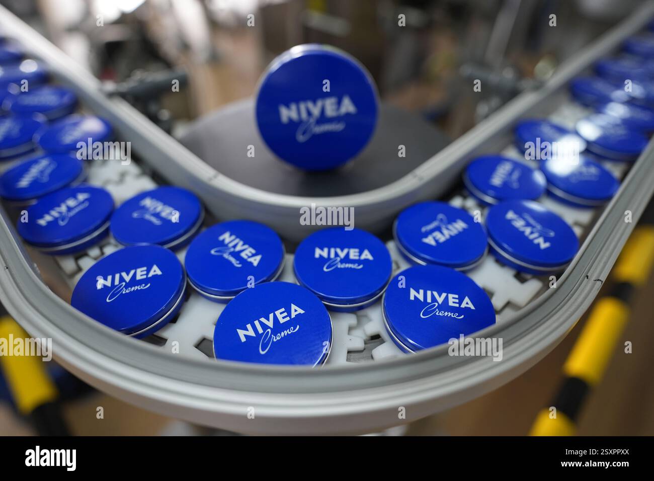 Hamburg, Germany. 25th Feb, 2025. Nivea cream cans lie on a conveyor ...