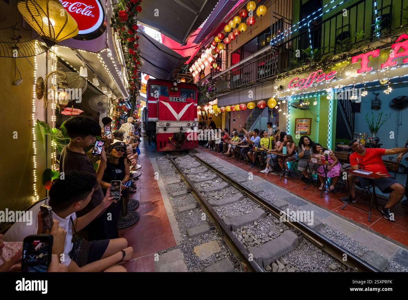 Many tourists gather in the colourfully decorated Train Street, sit in ...