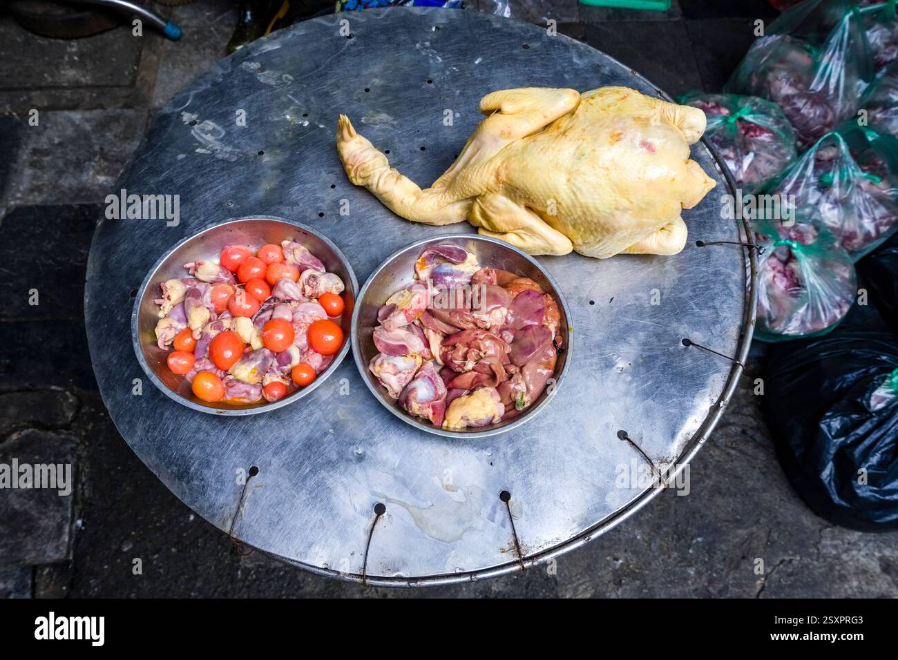 A boiled chicken and offal are offered for sale at one of the many ...