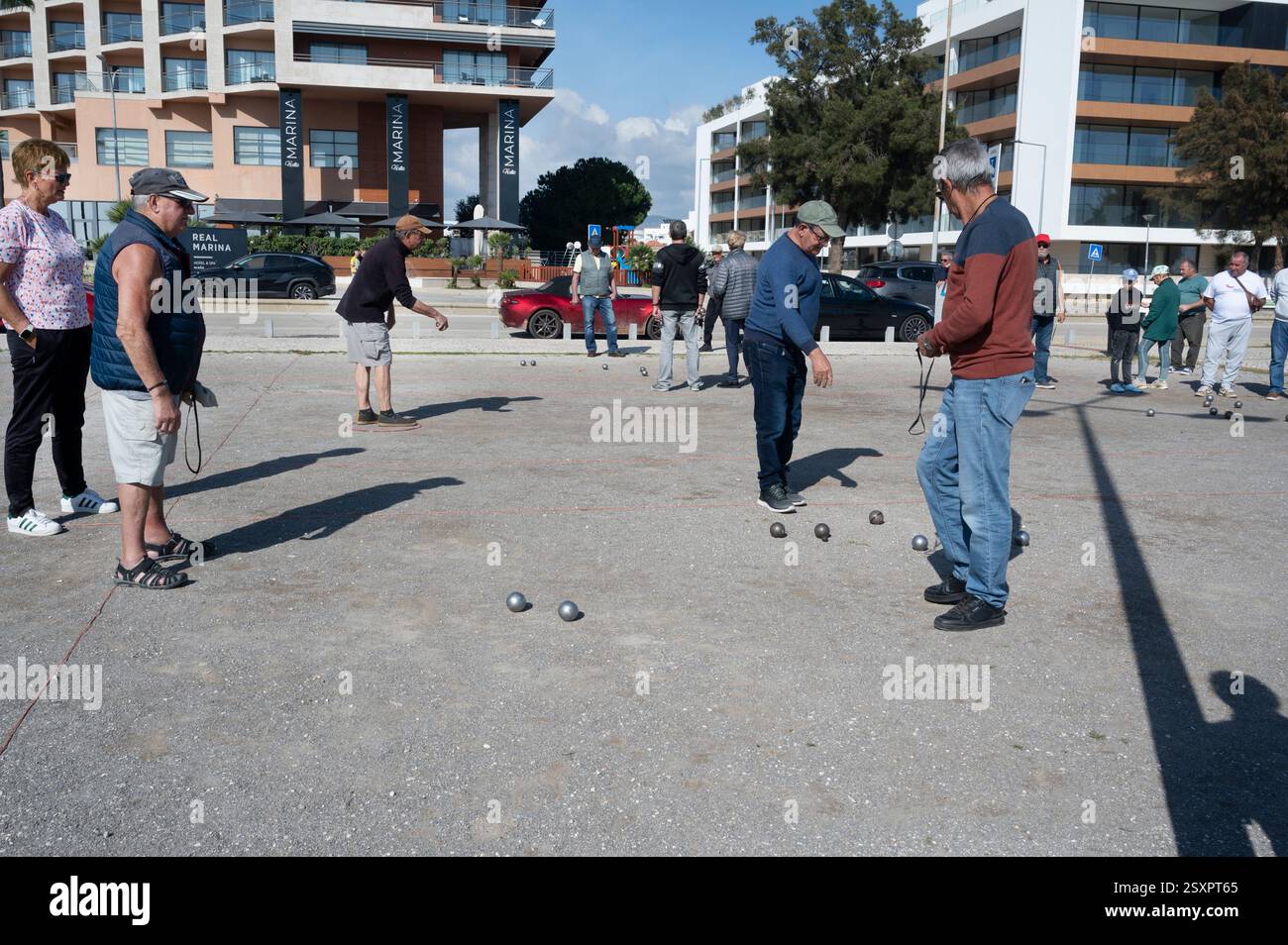 Portugal, Olhão, Algarve. A group of older men (and one women) play ...