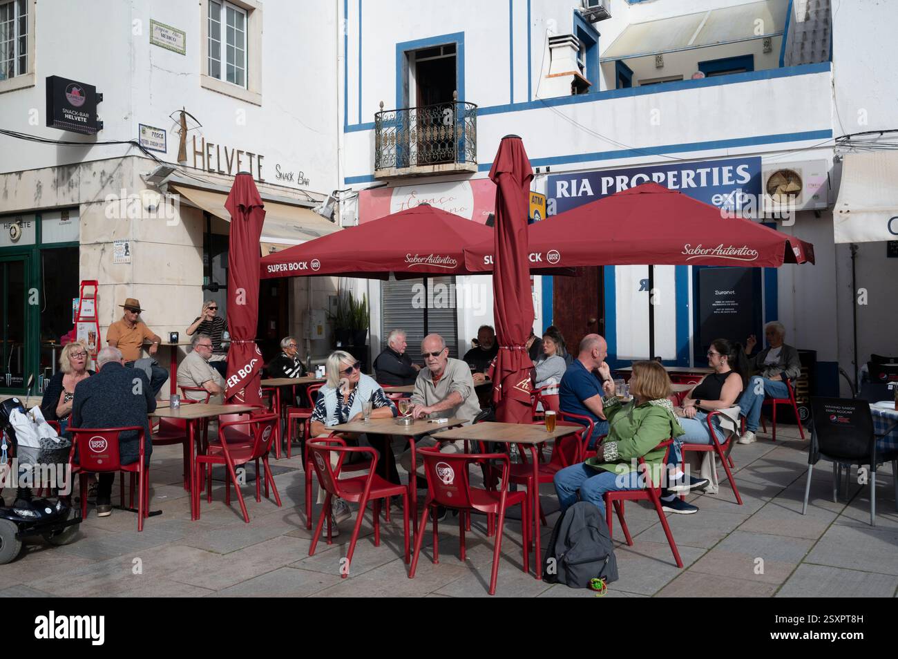 Portugal, Olhão, Algarve. Helvete snack bar. People have a drink in the ...