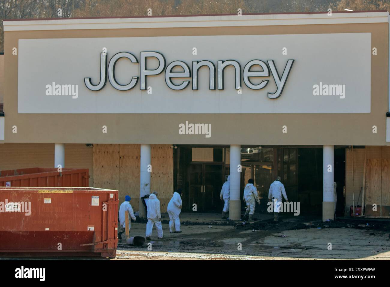 Workers in hazardous materials suits enter a flooded JCPenney department store to begin cleanup ...