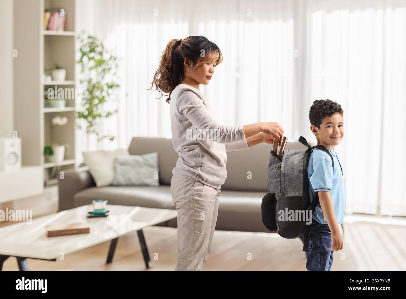 Mother packing a boys school backpack at home Stock Photo - Alamy