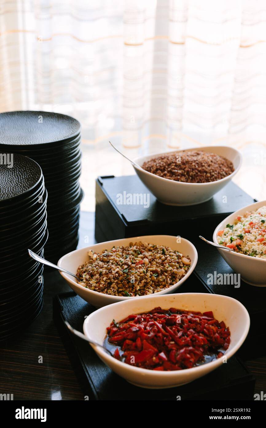 Various colorful dishes arranged on a table with stack of plates during ...
