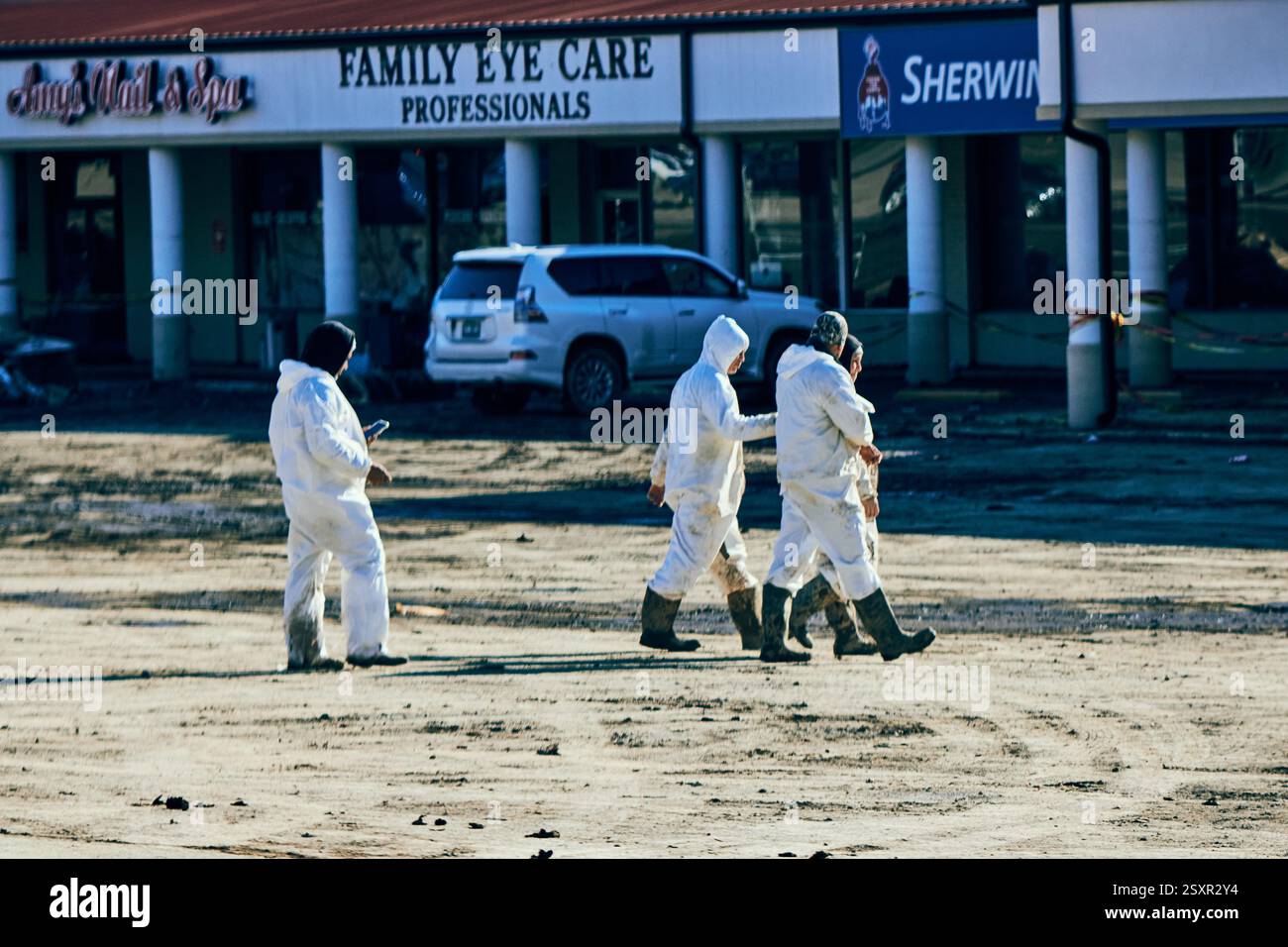 Workers in protective gear begin cleanup efforts after floods destroyed ...