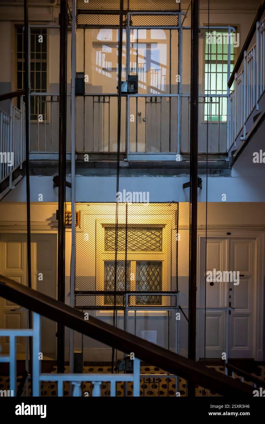 Interior staircase shaft and elevator cables in an old apartment ...