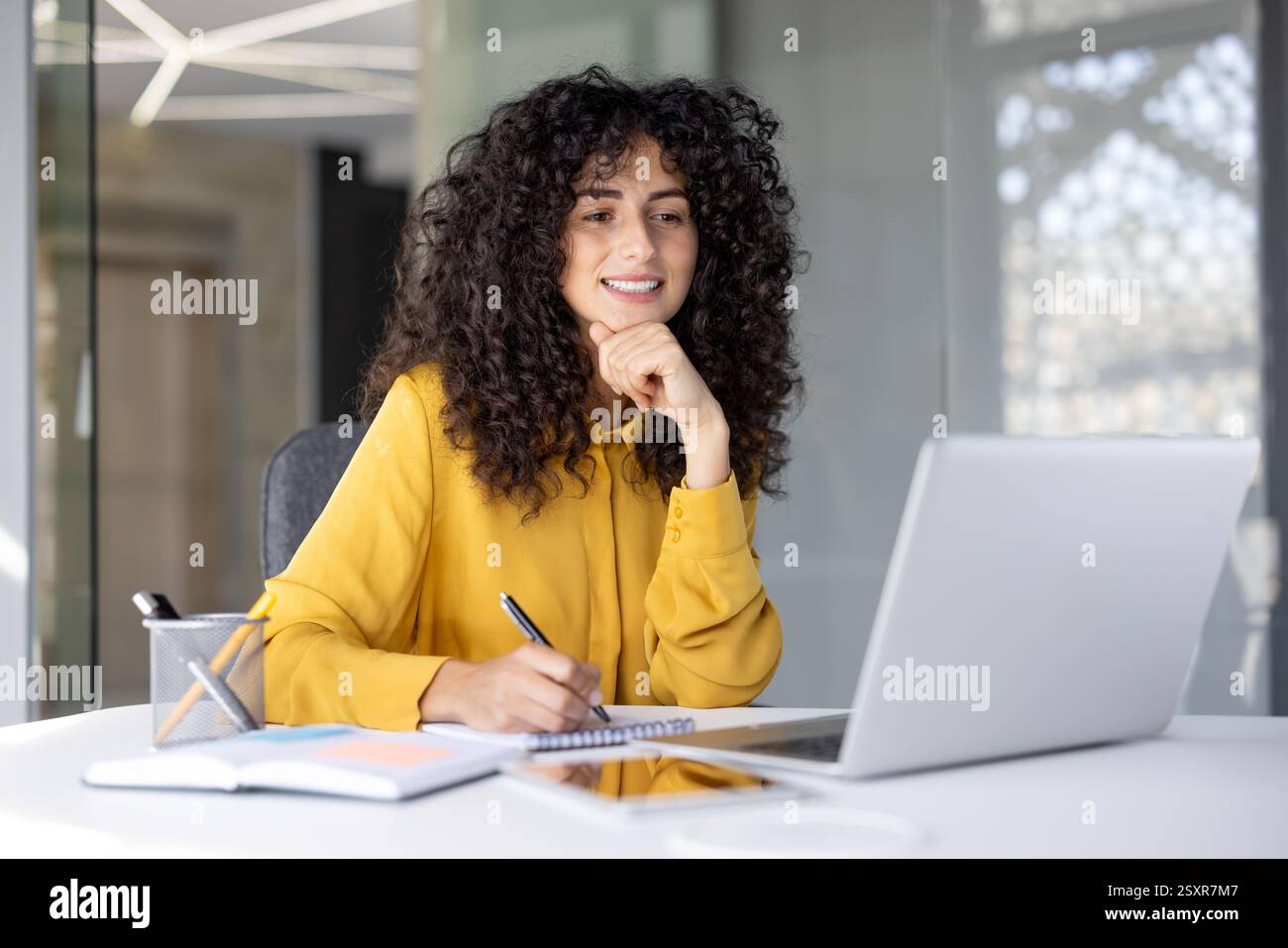 Businesswoman filling out tax forms online. Woman smiling and happy ...