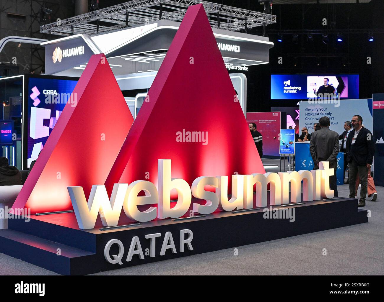 WEB SUMMIT QATAR 2025 - DAY THREE People walk past a Web Summit logo at DECC during the third ...