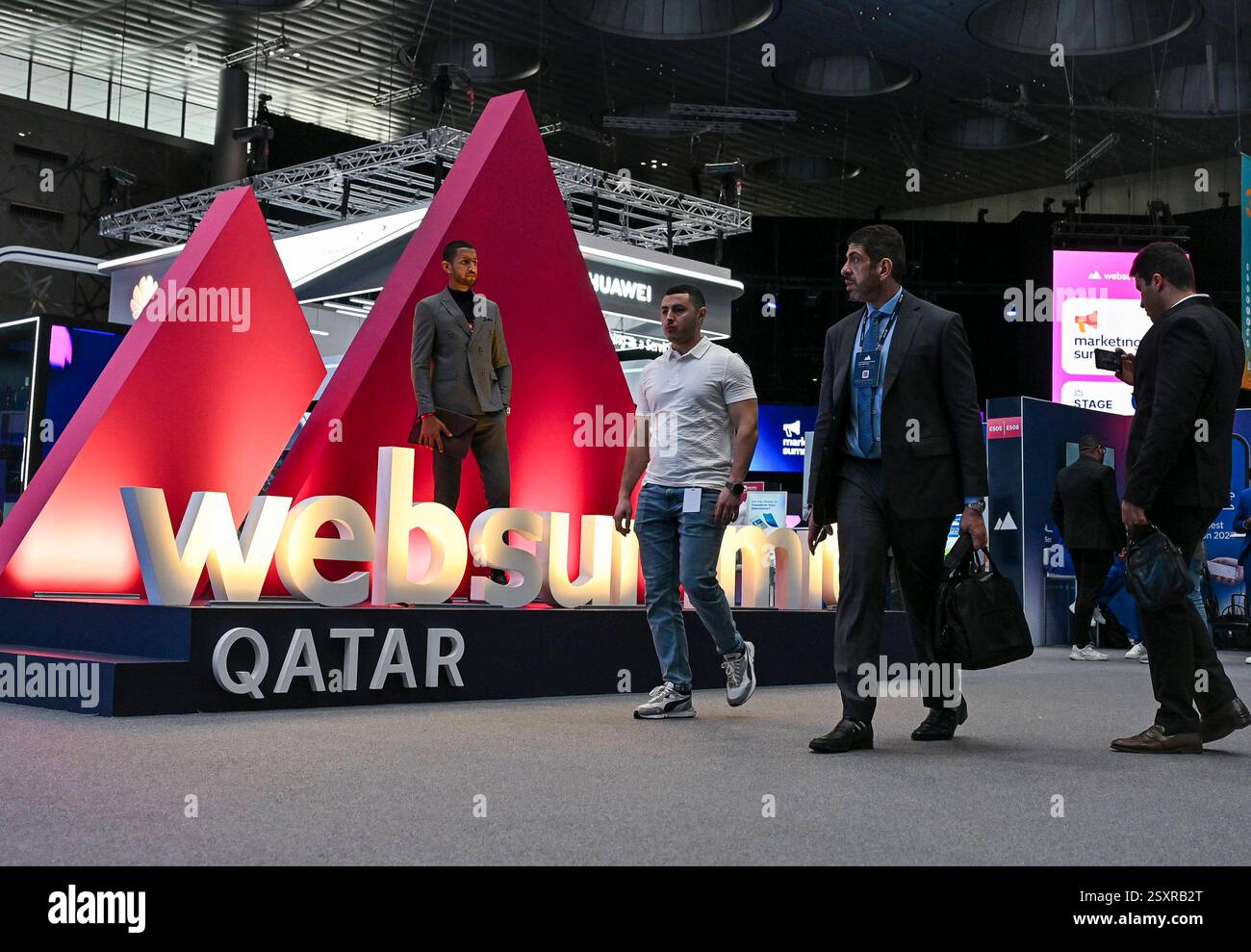 WEB SUMMIT QATAR 2025 - DAY THREE People walk past a Web Summit logo at ...
