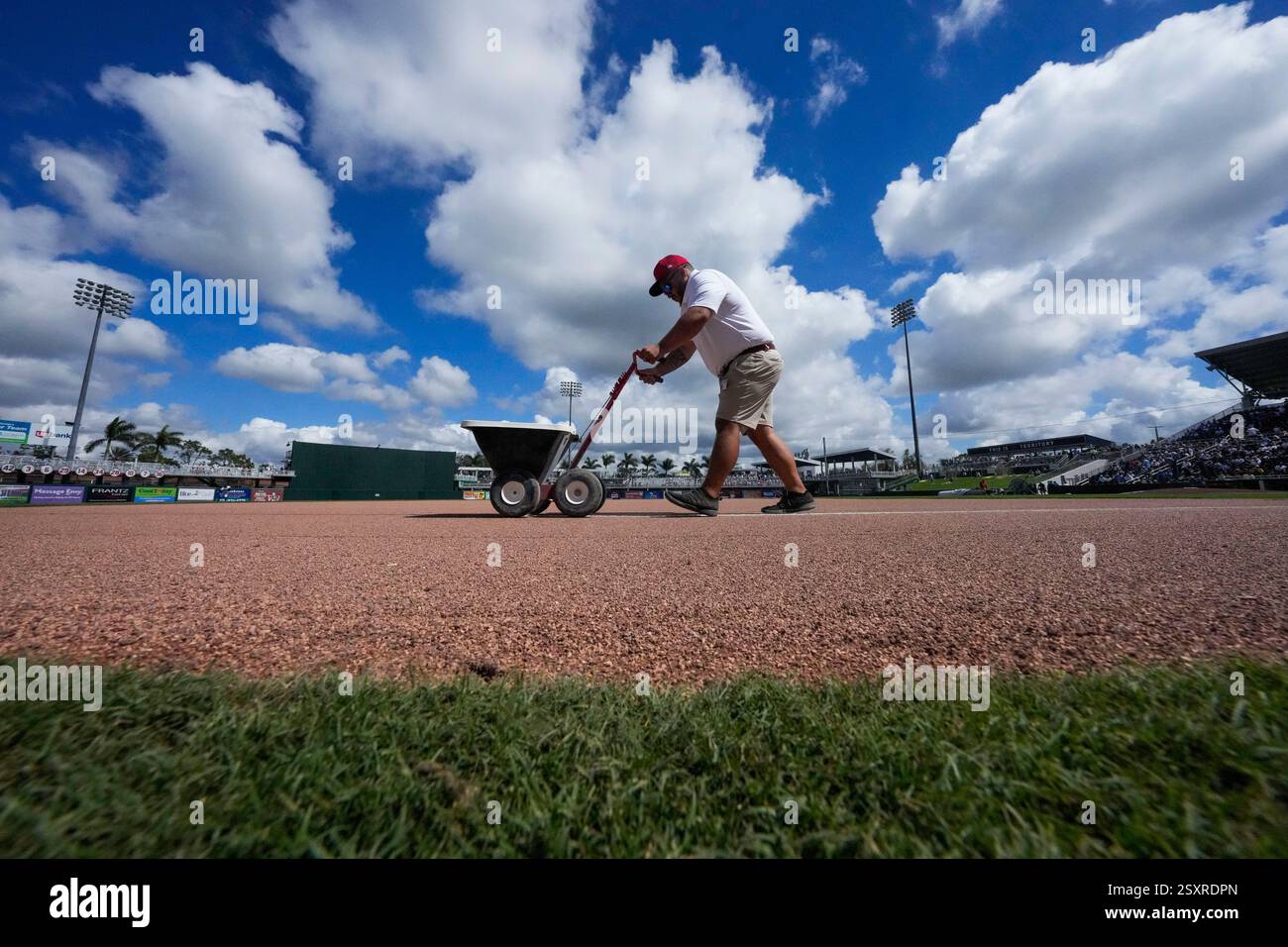 A grounds keeper paints the baselines before a spring training baseball ...