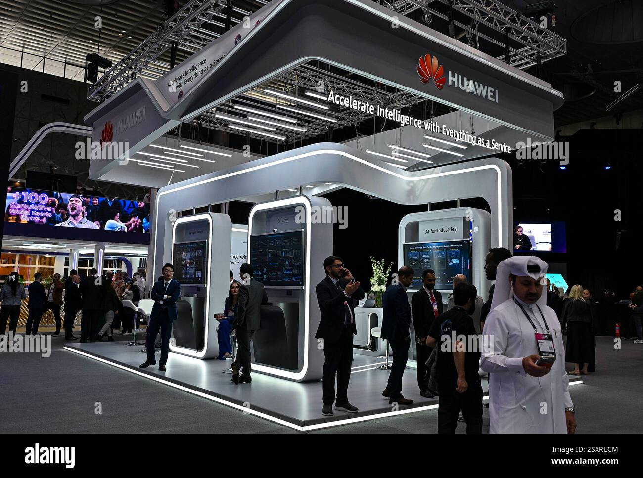 WEB SUMMIT QATAR 2025 - DAY THREE People walk past a Huawei stand ...