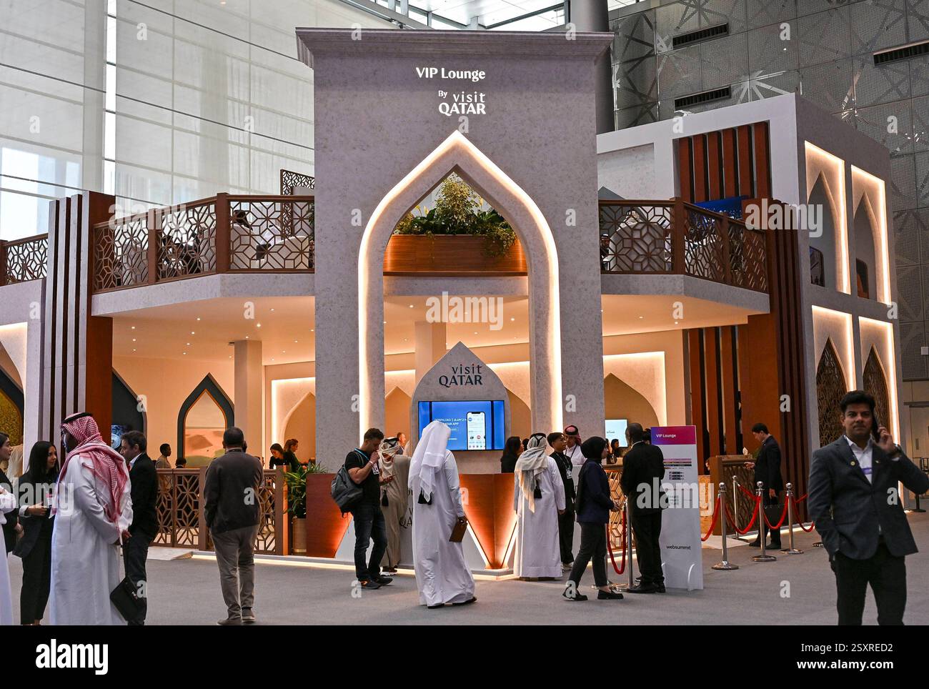 WEB SUMMIT QATAR 2025 - DAY THREE People walk past a Qatar Tourism ...