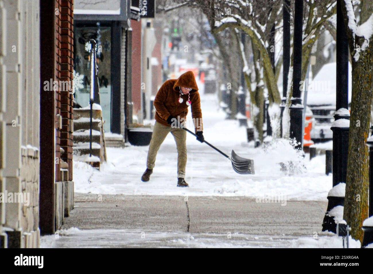 A shovel full of snow gets a hoist along North Franklin Street in ...