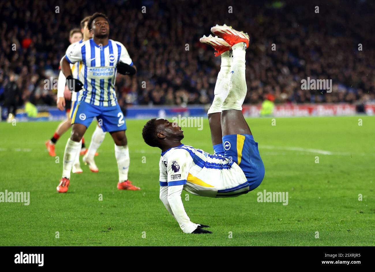 Brighton and Hove Albion's Yankuba Minteh attempts to clear the ball ...