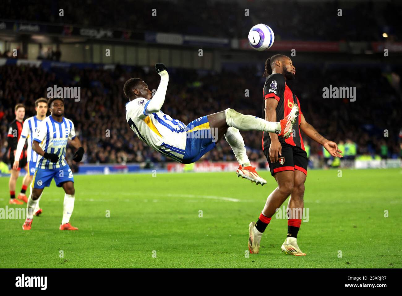 Brighton and Hove Albion's Yankuba Minteh attempts to clear the ball ...