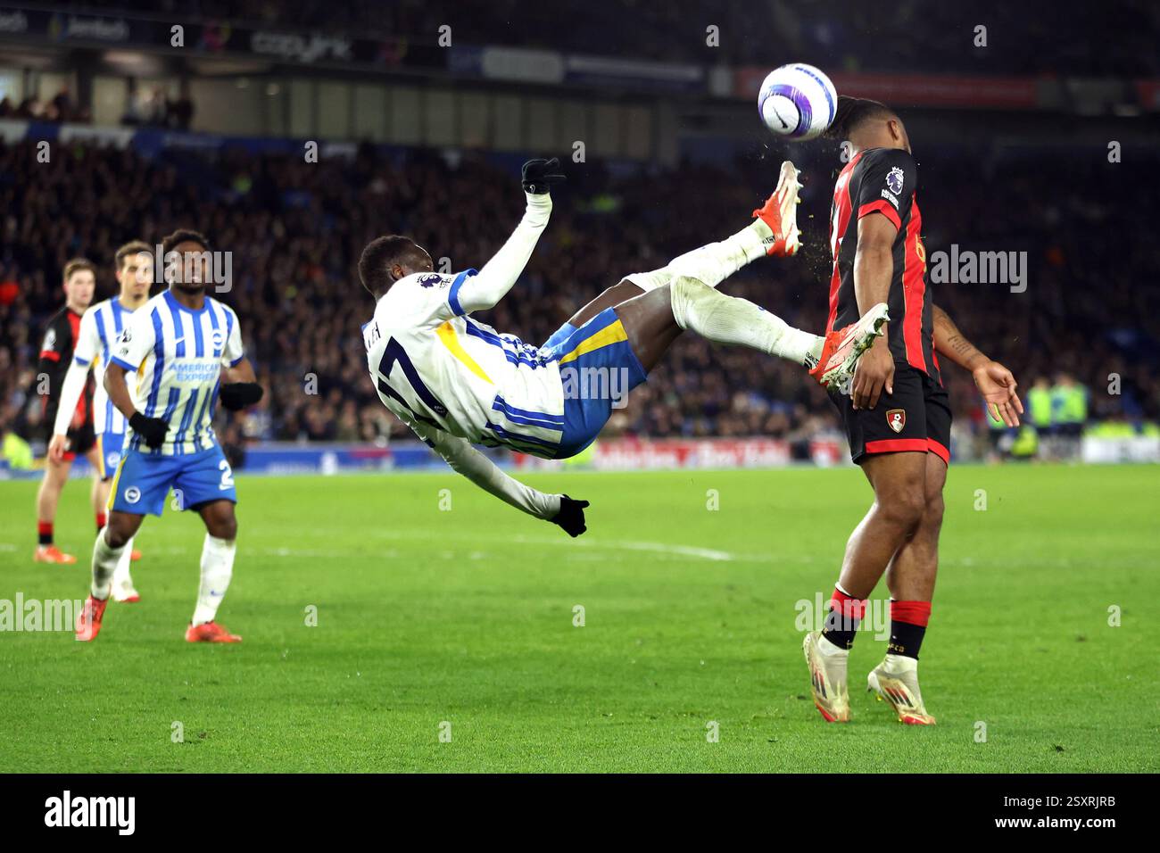 Brighton and Hove Albion's Yankuba Minteh attempts to clear the ball ...