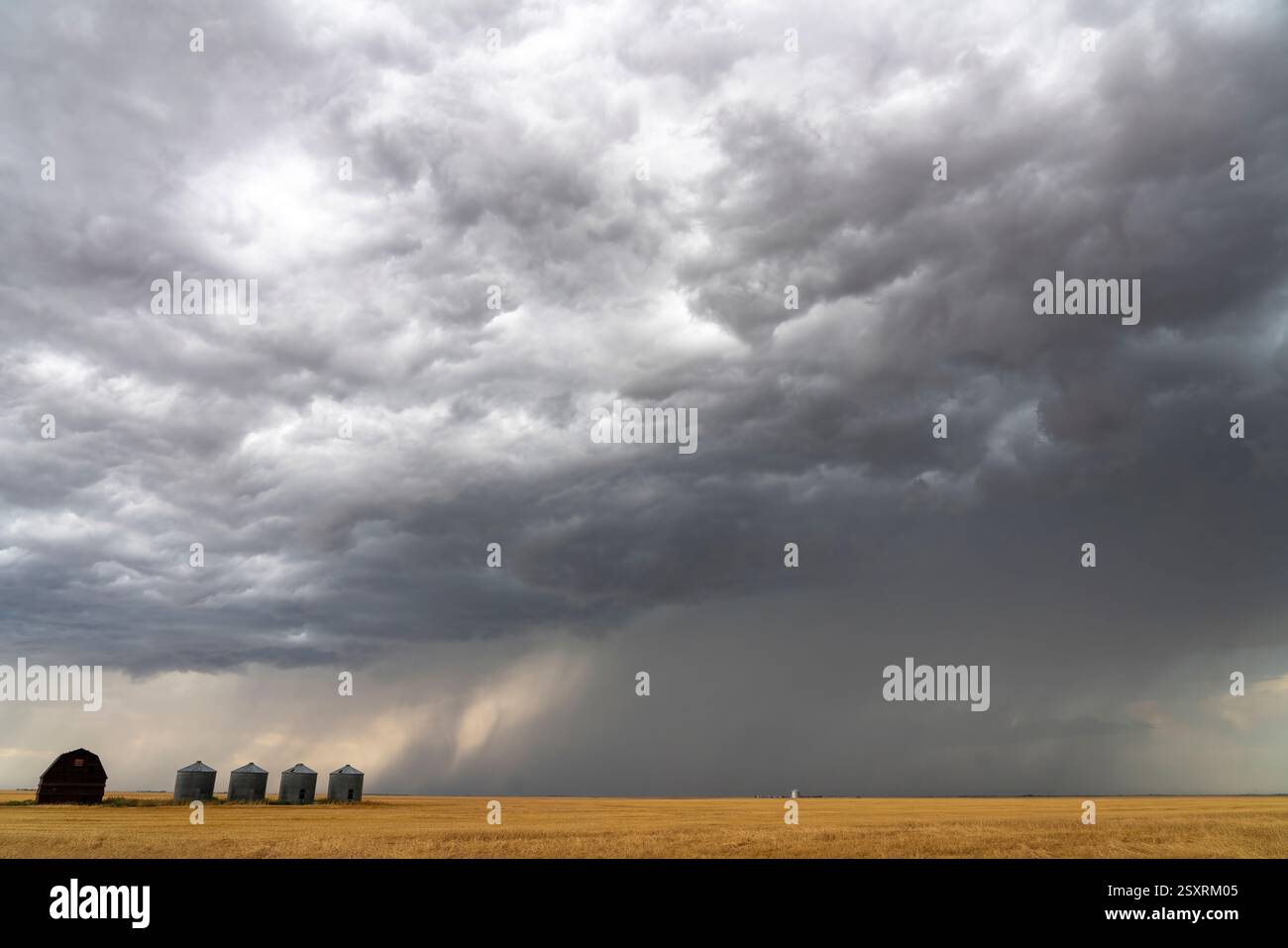 Dark storm clouds gathering over a farm in the prairie Stock Photo - Alamy