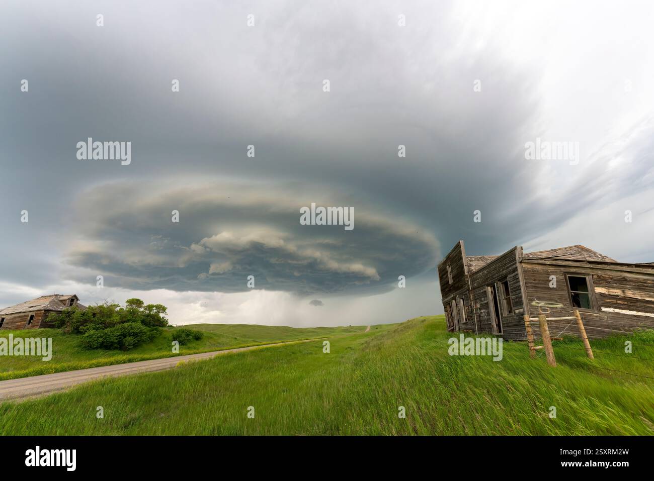 Dramatic supercell storm cloud forming over abandoned wooden houses and ...
