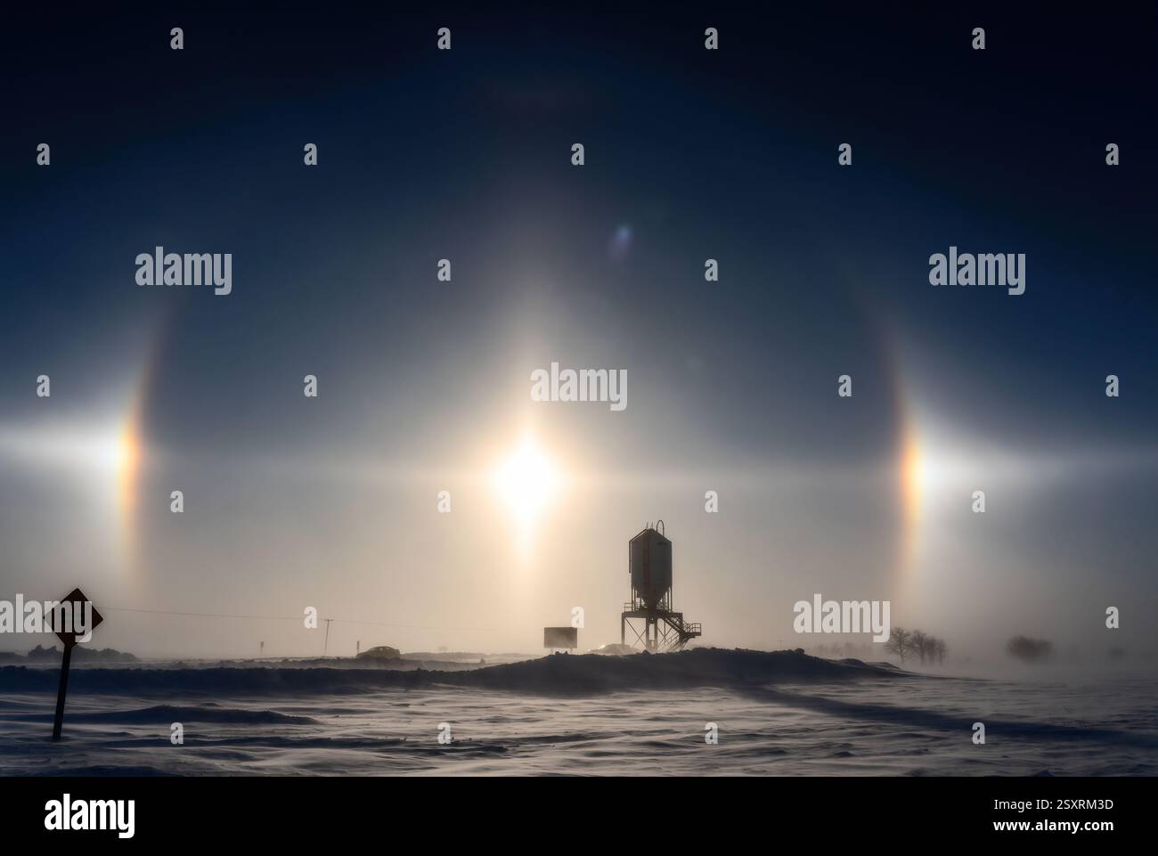 Beautiful sun dogs illuminating a cold winter landscape, creating a ...