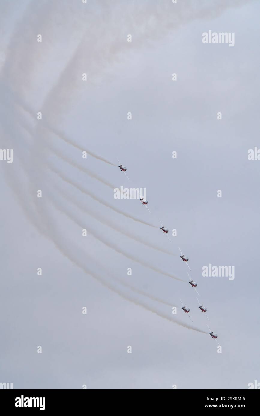 Eight planes flying in formation, leaving smoke trails during an ...