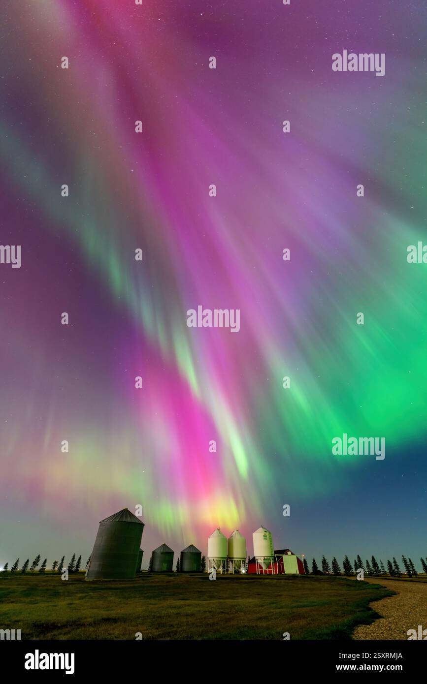 Colorful northern lights painting the night sky above a farm in the ...