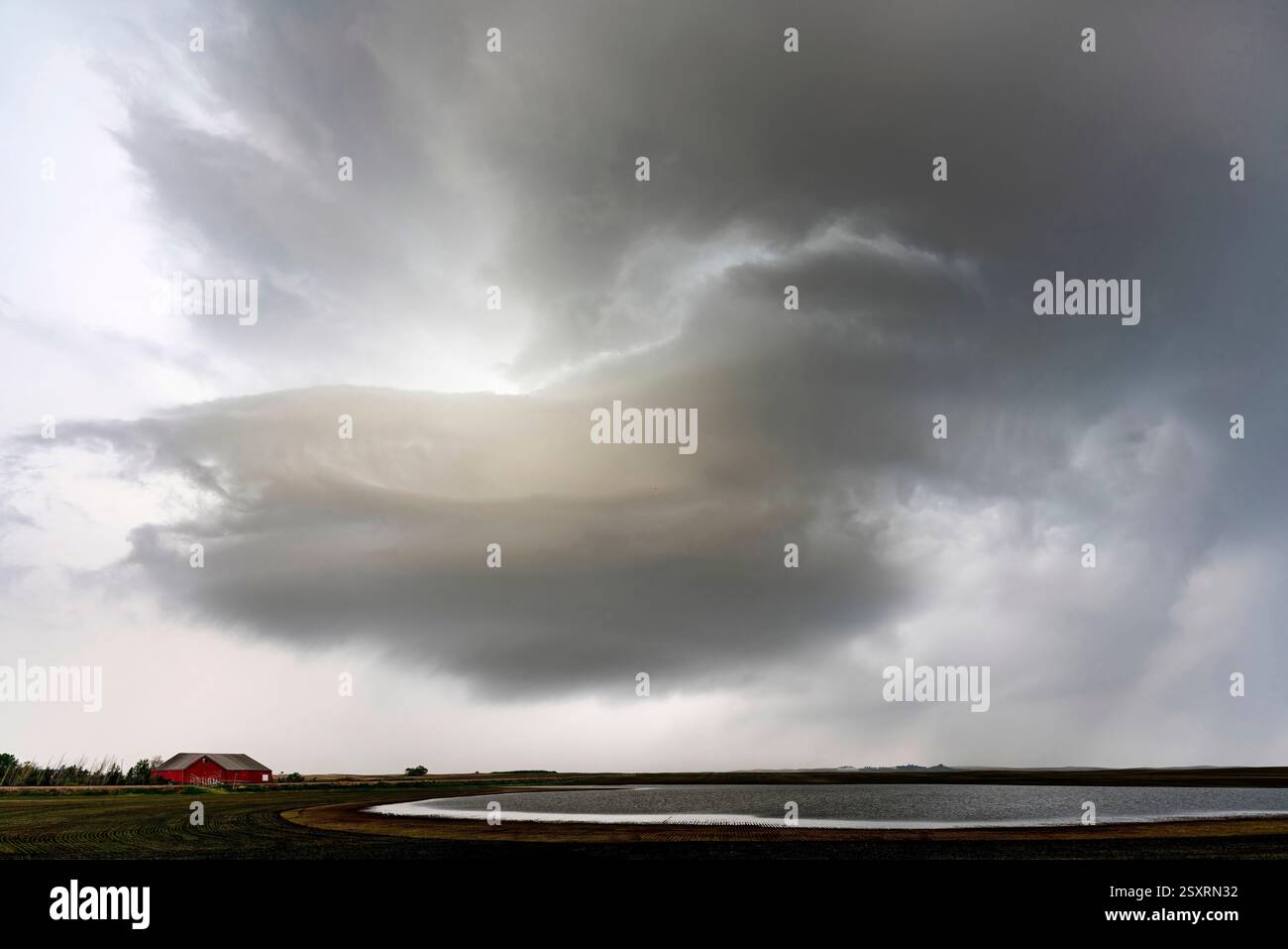 Ominous supercell storm clouds forming over a rural landscape, creating ...
