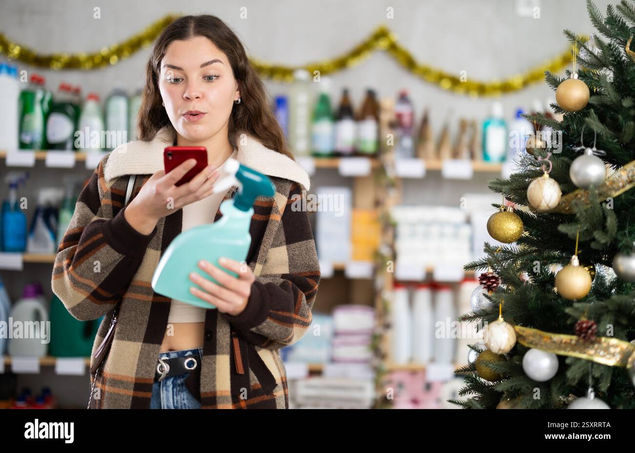 Young woman scanning qr code for cleaning spray Stock Photo - Alamy