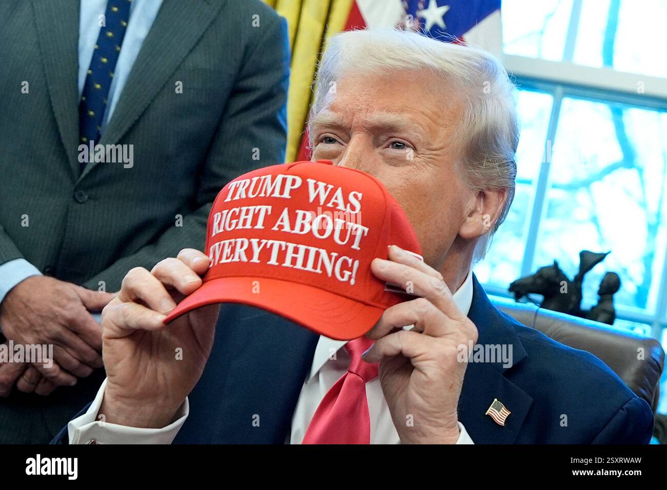 US President Donald Trump holds a hat eading "Trump was right about ...