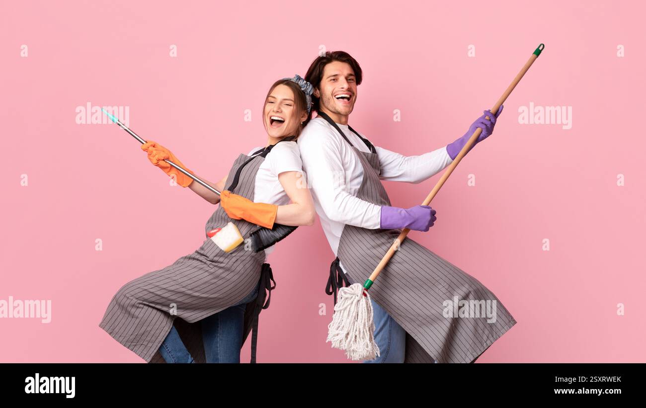 Cleaning Fun. Couple Fooling With Mop And Broom On Pink Background ...