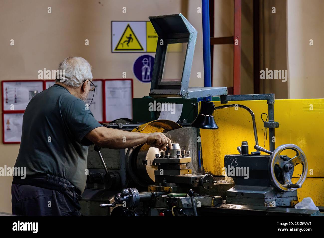 Factory worker working on lathe in metalworking factory Stock Photo - Alamy