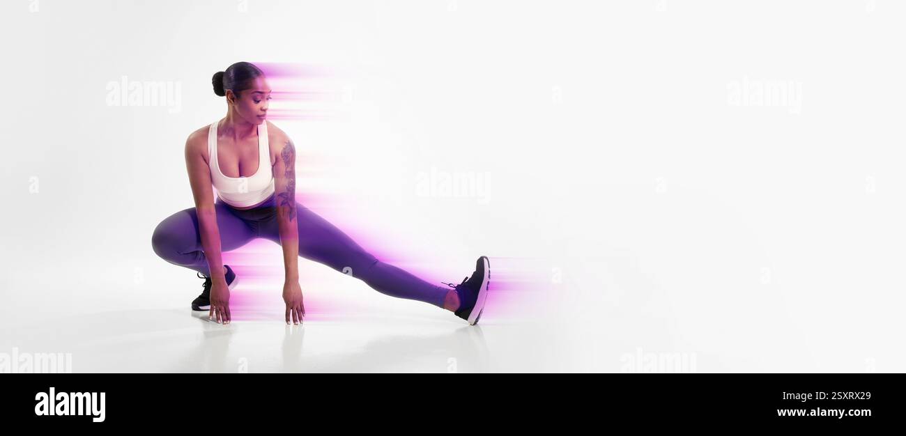 African American lady making extended leg squat pose stretching legs ...
