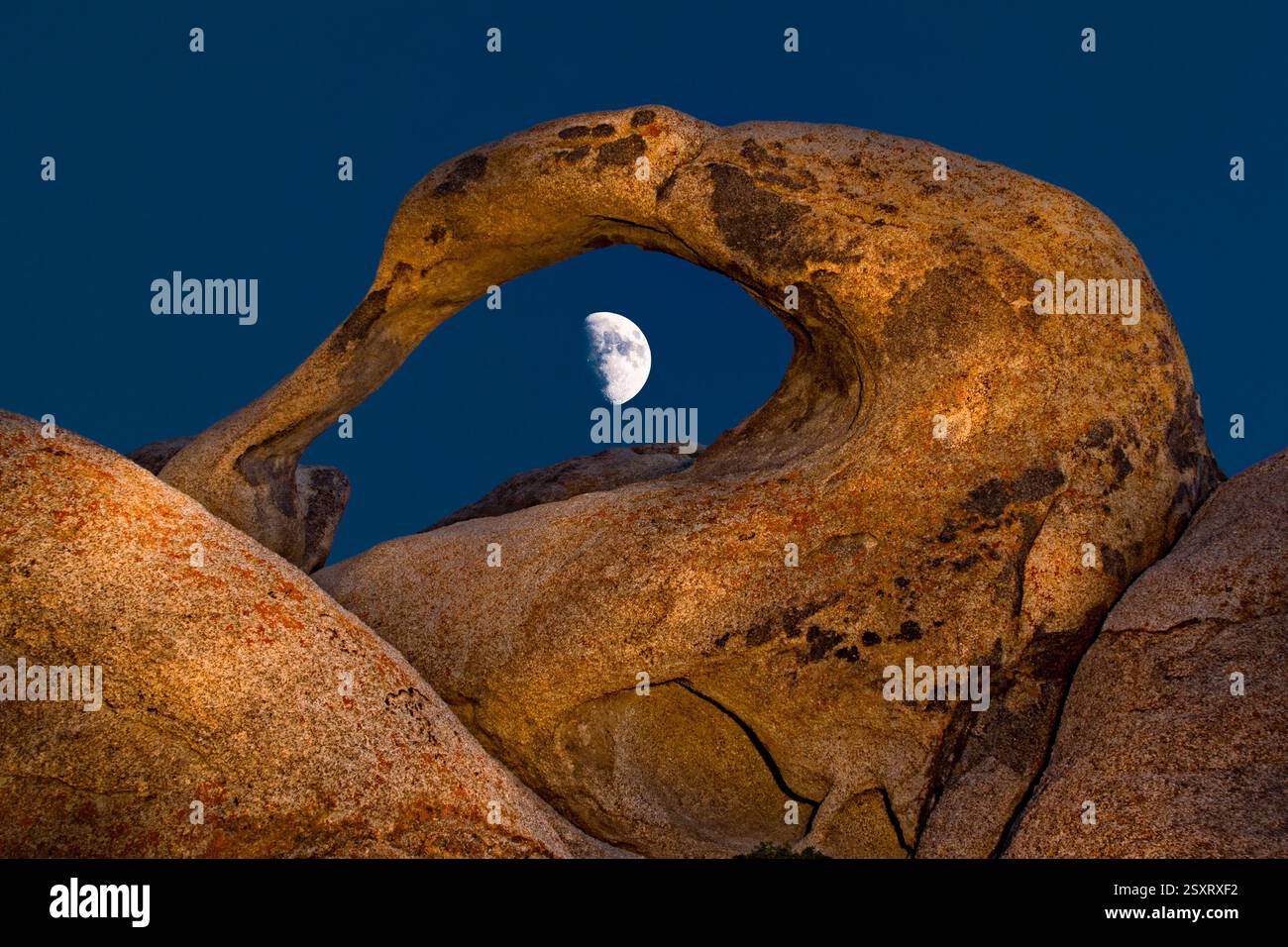 Large rock formation with a hole in it. The moon is in the sky above ...