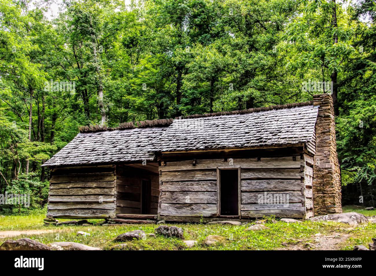 Log cabin with a slanted roof. The roof is made of wood shingles. The ...