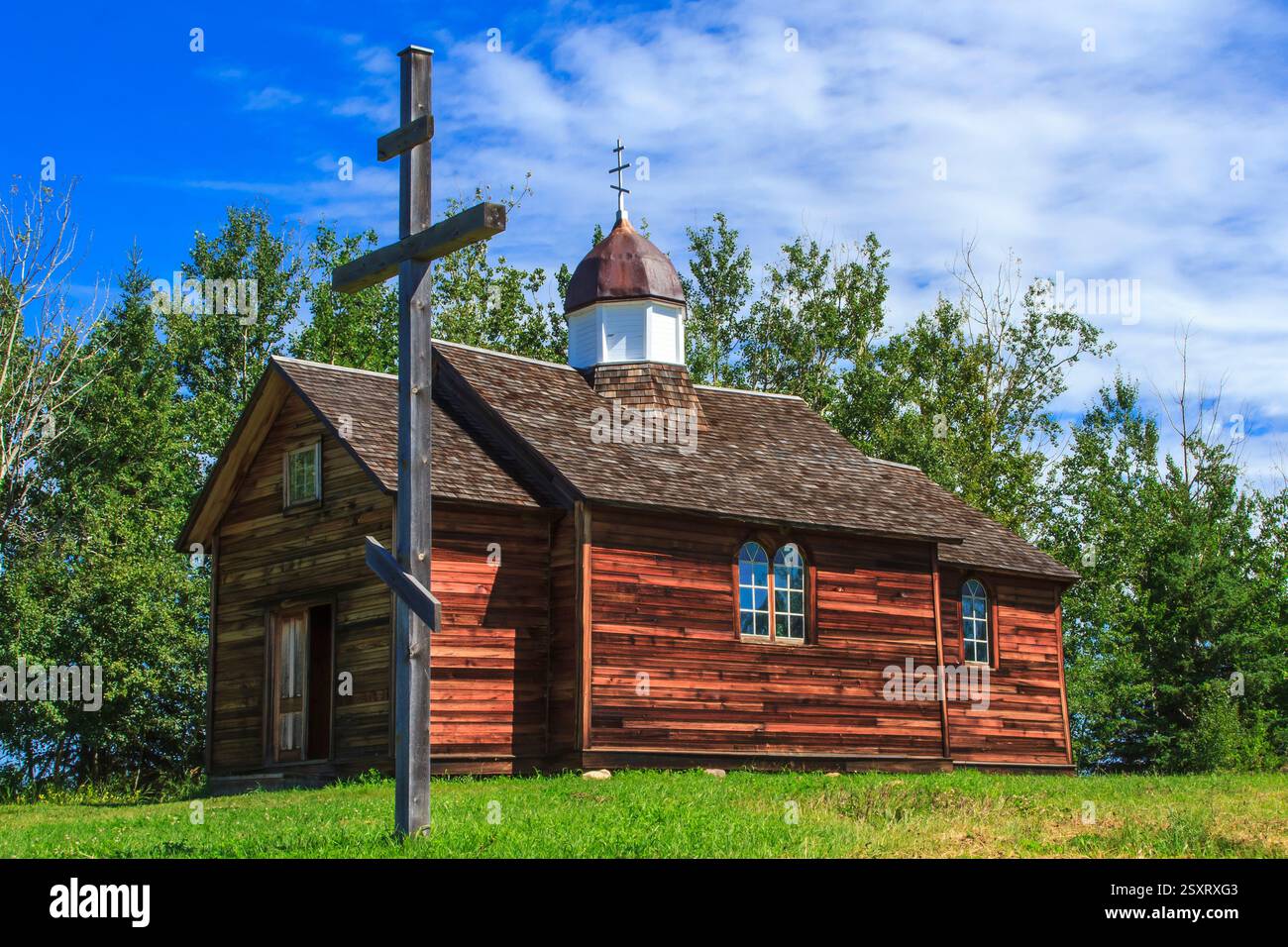 Small red church with a cross on the front. The cross is made of wood ...