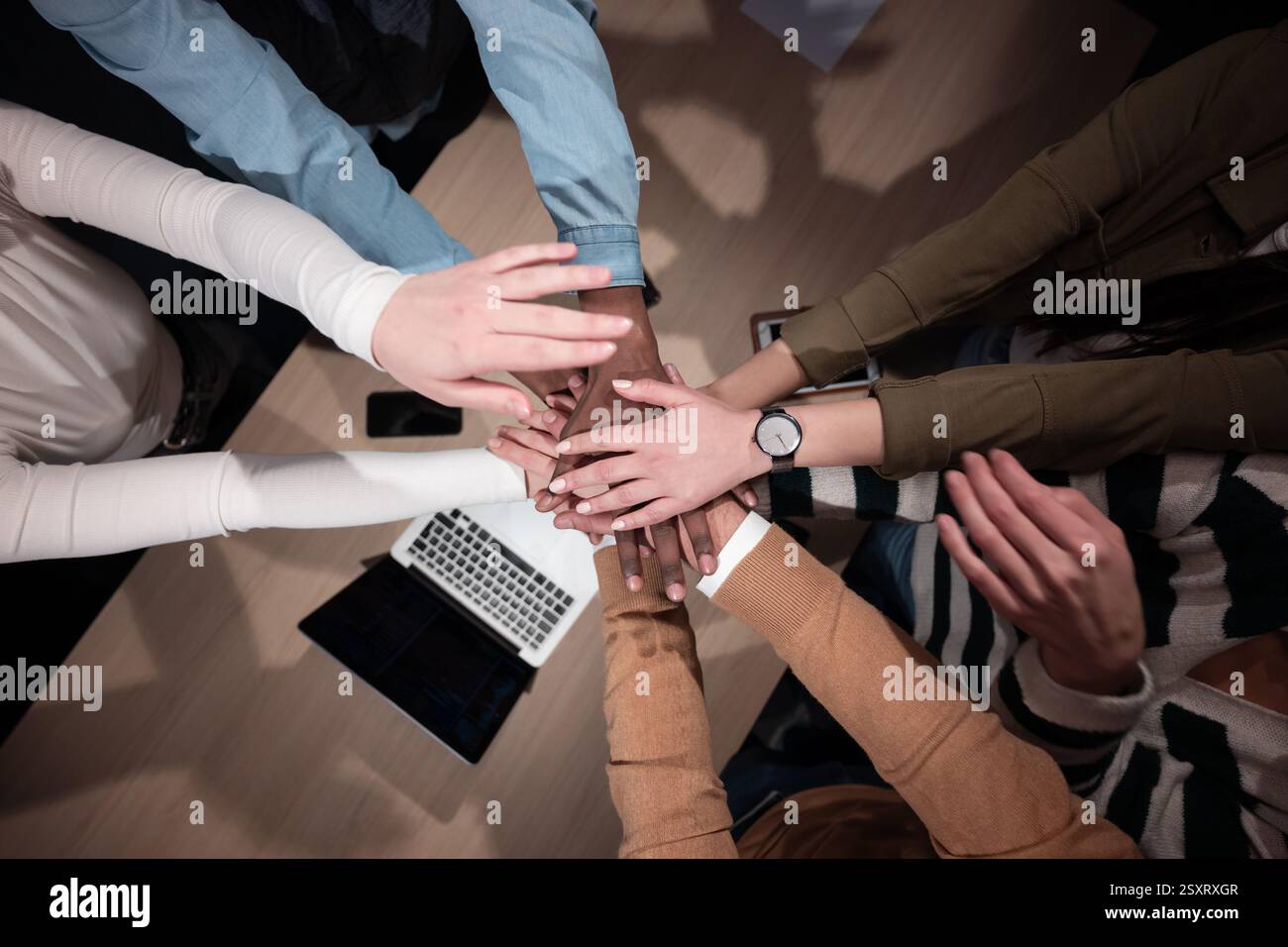 Business people team stacking hands to promote collaboration, inclusion, and equality in the ...