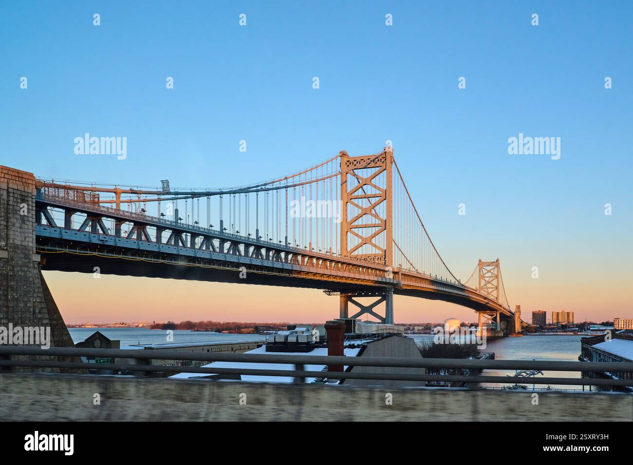 The Benjamin Franklin bridge as seen from a highway during dusk Stock ...