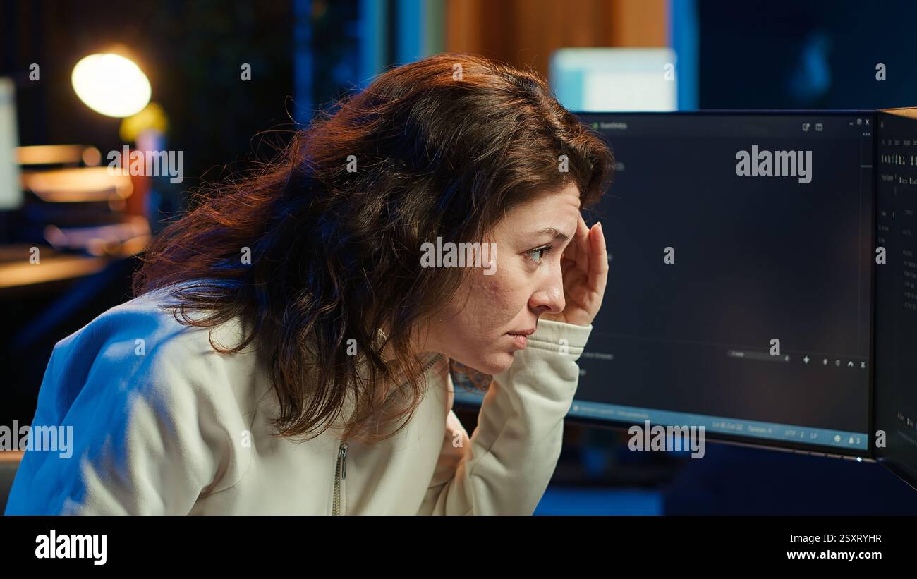 Cybersecurity specialist looking confused at computer screen while trying to fix broken code ...