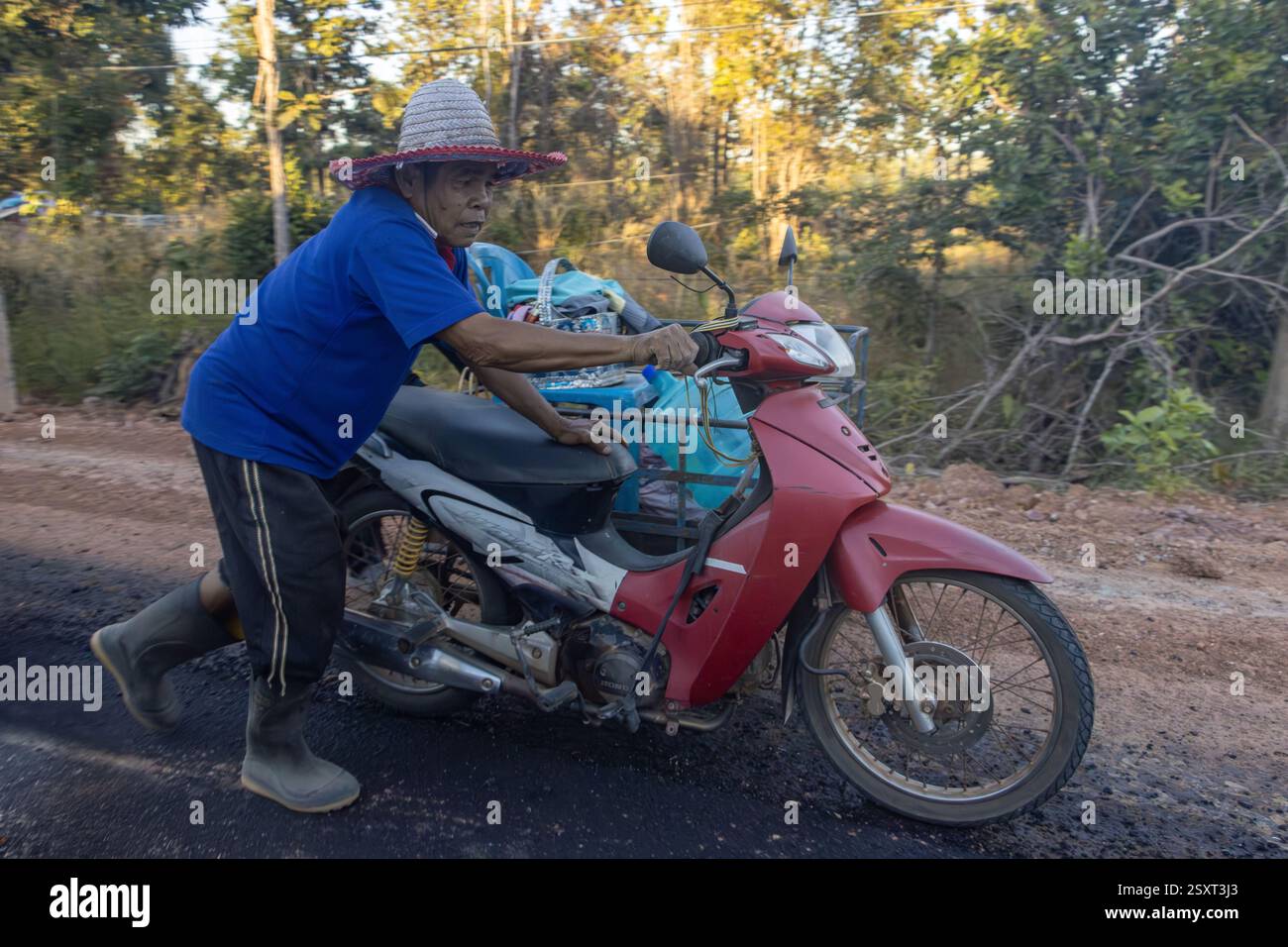 UBON RATCHATHANI, THAILAND, DEC 16 2024, Old man pushing a motorbike ...